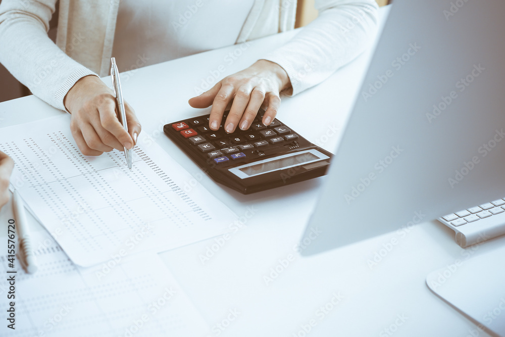Accountant checking financial statement or counting by calculator ...