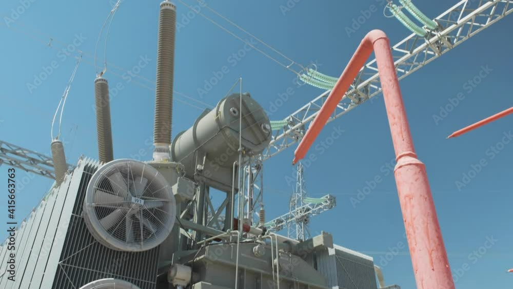 Red tubes of fire safety system near modern transformer with operating ...