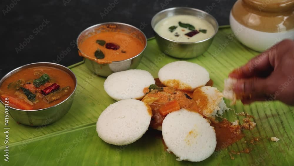 Indian Man hand eating Idli idly sambar tomato coconut chutney served ...