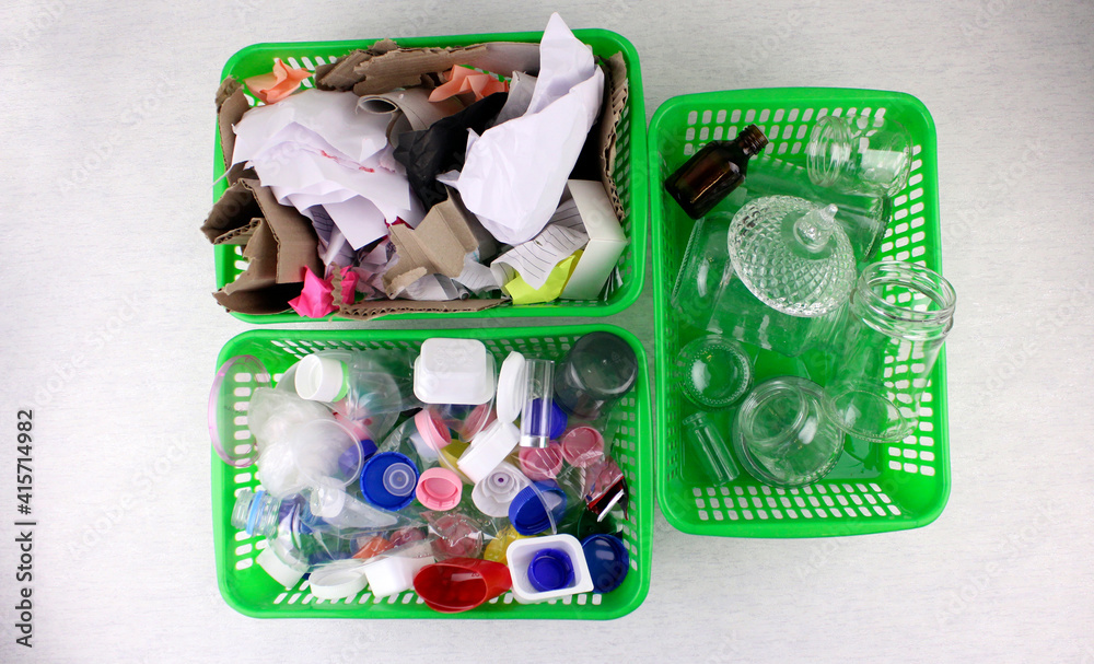 Sorting waste into plastic, paper and glass in different containers ...