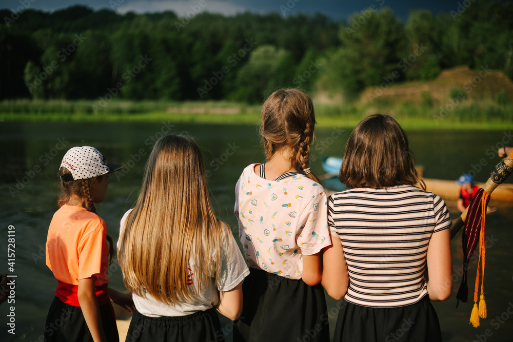 Foto de Group of children stand from backs and cheer for their friends ...