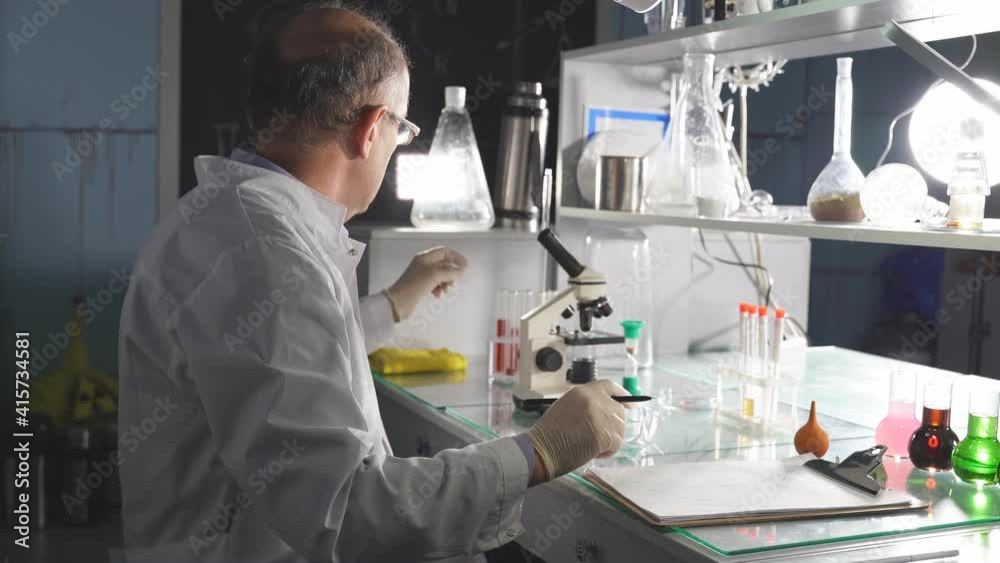 Male scientist working in modern lab, making microbiology research and ...