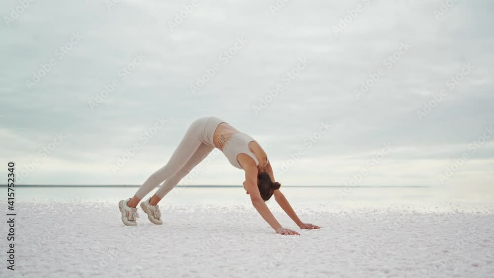 slender mixed race woman practices yoga outdoors in nature, doing ...
