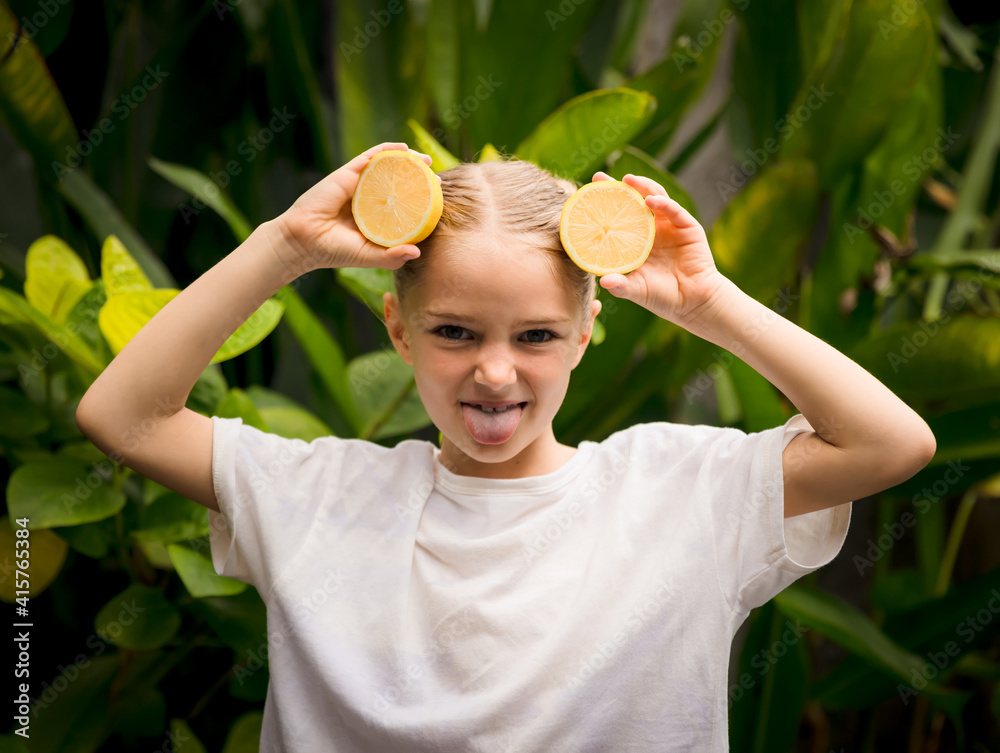 Little girl with two halves of fresh lemon. Caucasian girl holding ...