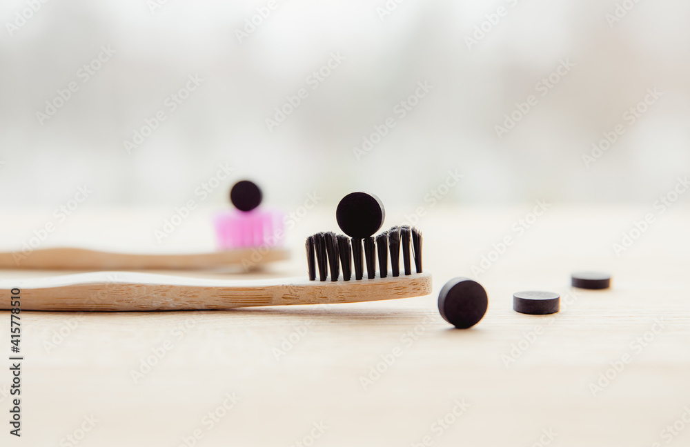 Side view of black activated charcoal toothpaste tablets. Dental care ...