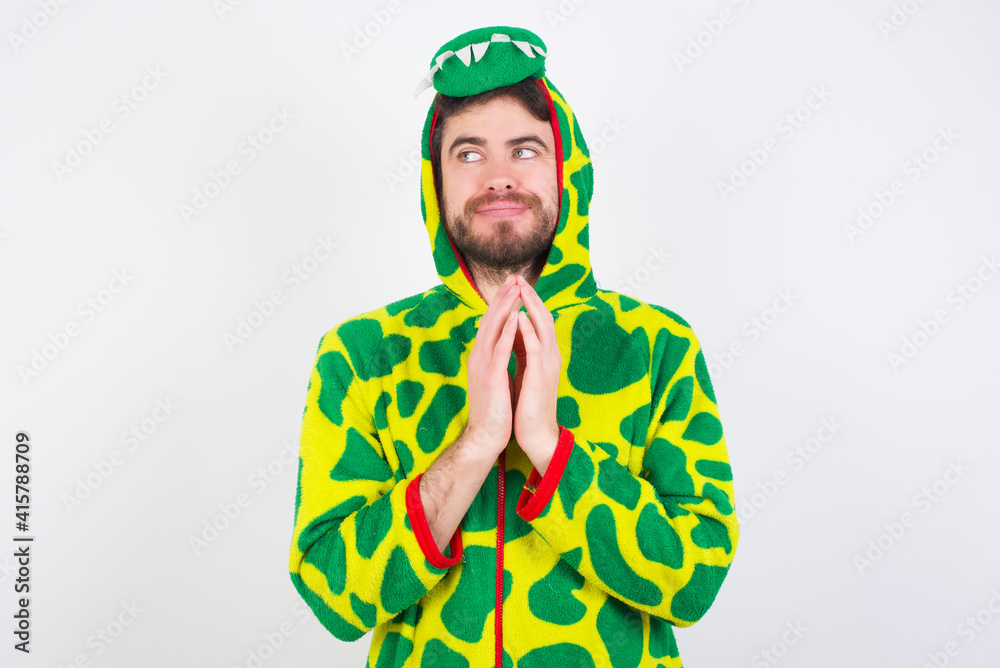 Charming cheerful young caucasian man wearing a pyjama standing against ...