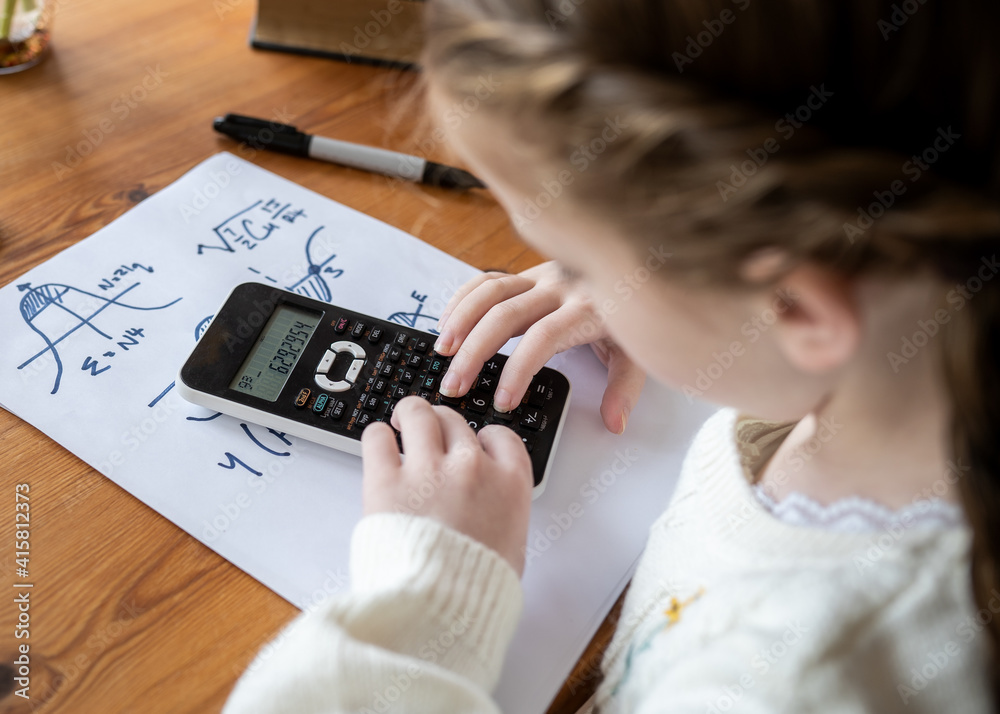 Cute pretty young girl doing complex maths writing calculations genius ...