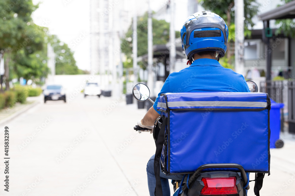 Delivery man wearing blue uniform riding motorcycle and delivery box ...