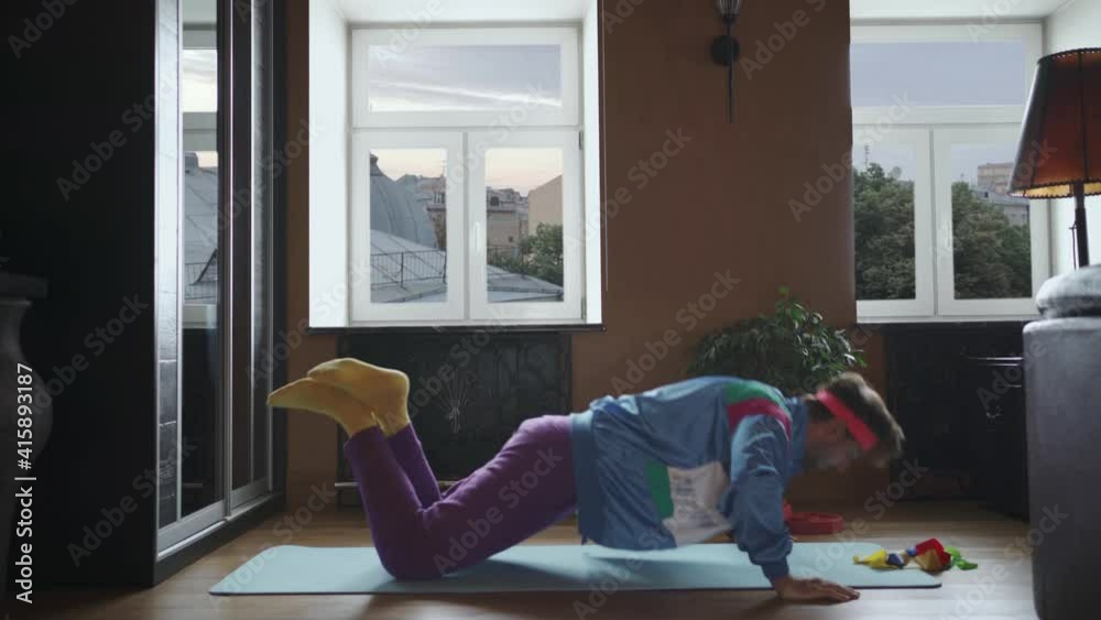 Funny whimsical guy lying on a fitness mat, doing push-ups from the ...