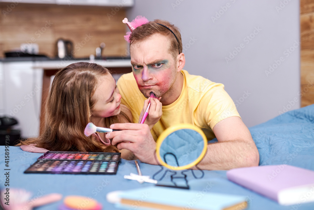 Kid girl putting on make up on father's face , using decorative ...