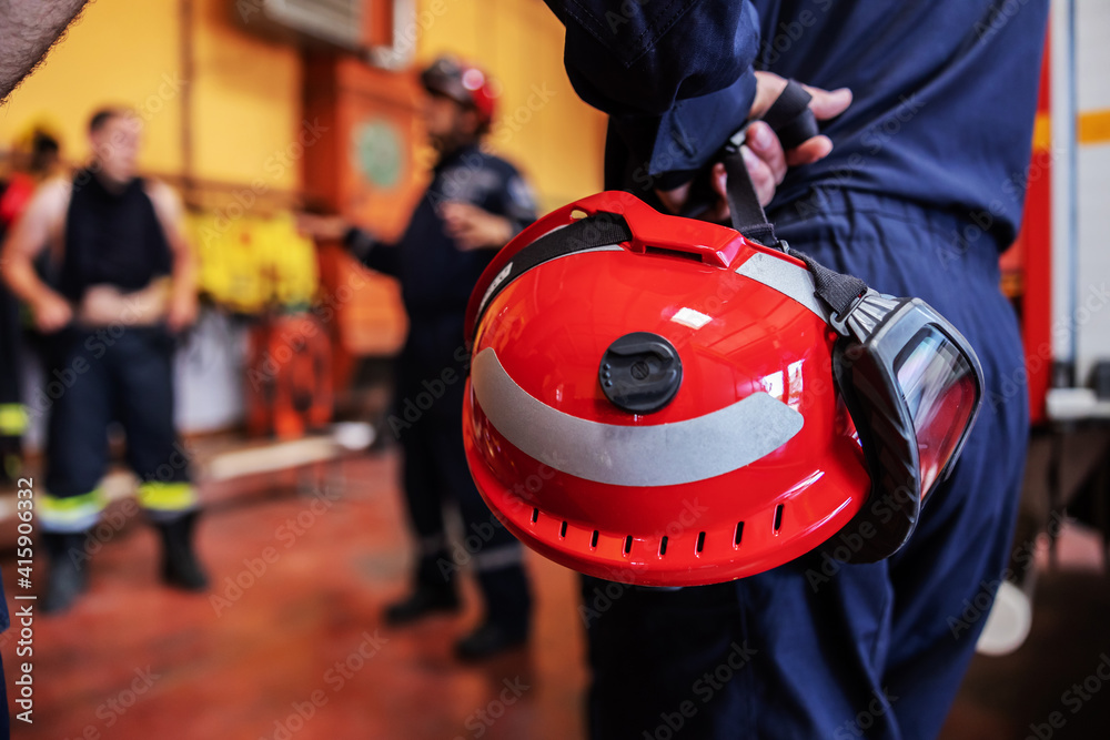 Closeup of fireman holding helmet and listening to a boss. Boss talking ...