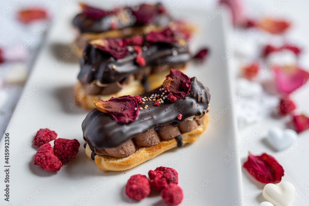 creamy chocolate eclair with edible flowers, rose petals and freeze ...