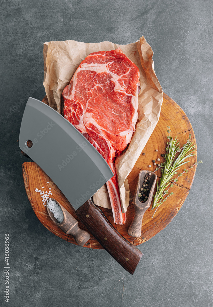 on a wooden block for meat a fresh raw tamahawk steak or a cowboy steak ...