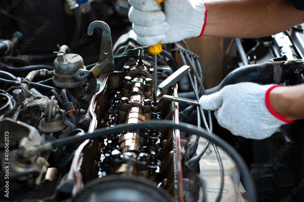 Auto mechanics are using tools to adjust and repair a car engine. Stock ...