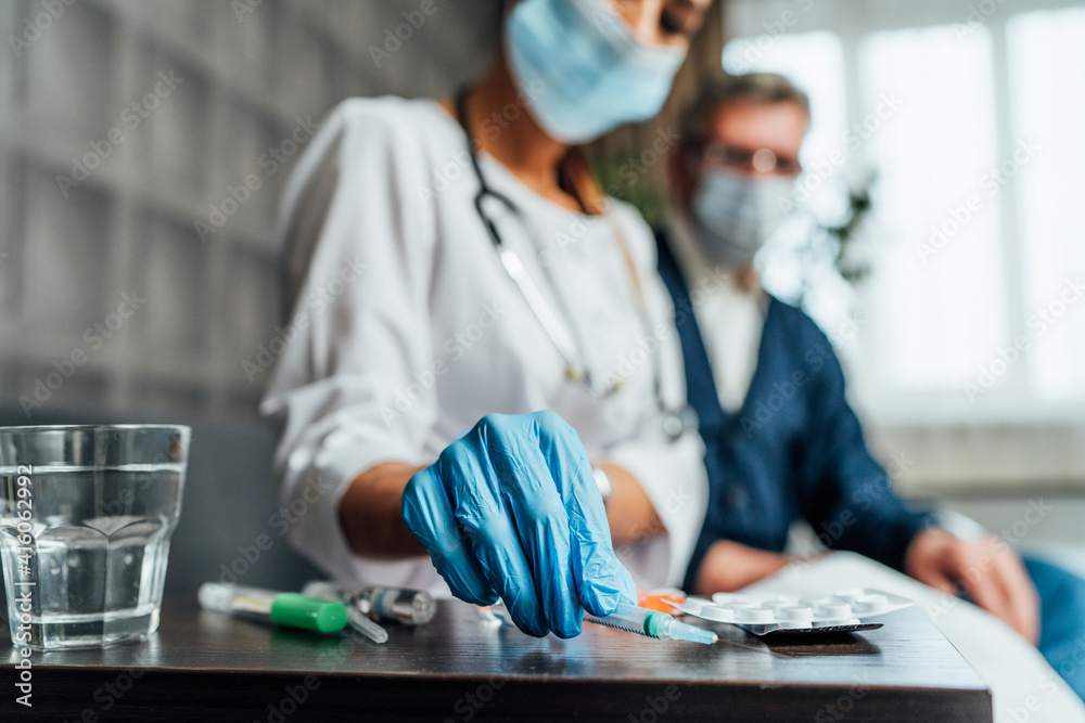 The focus is on the doctor's hand reaching for the injection. In the ...