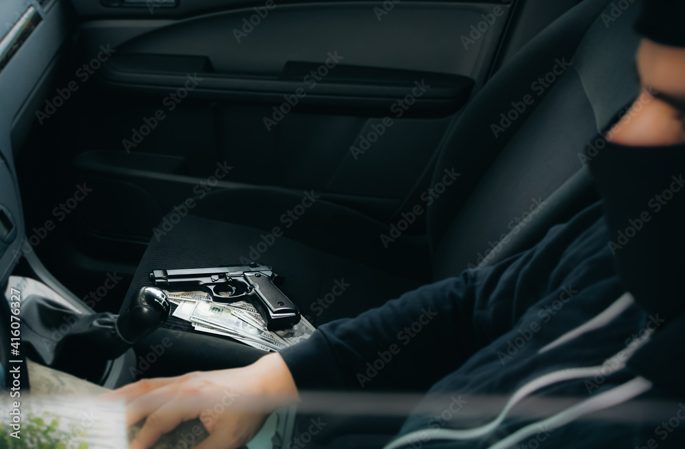 Theft of the car. Man behind the wheel. Gun with money lying on the ...