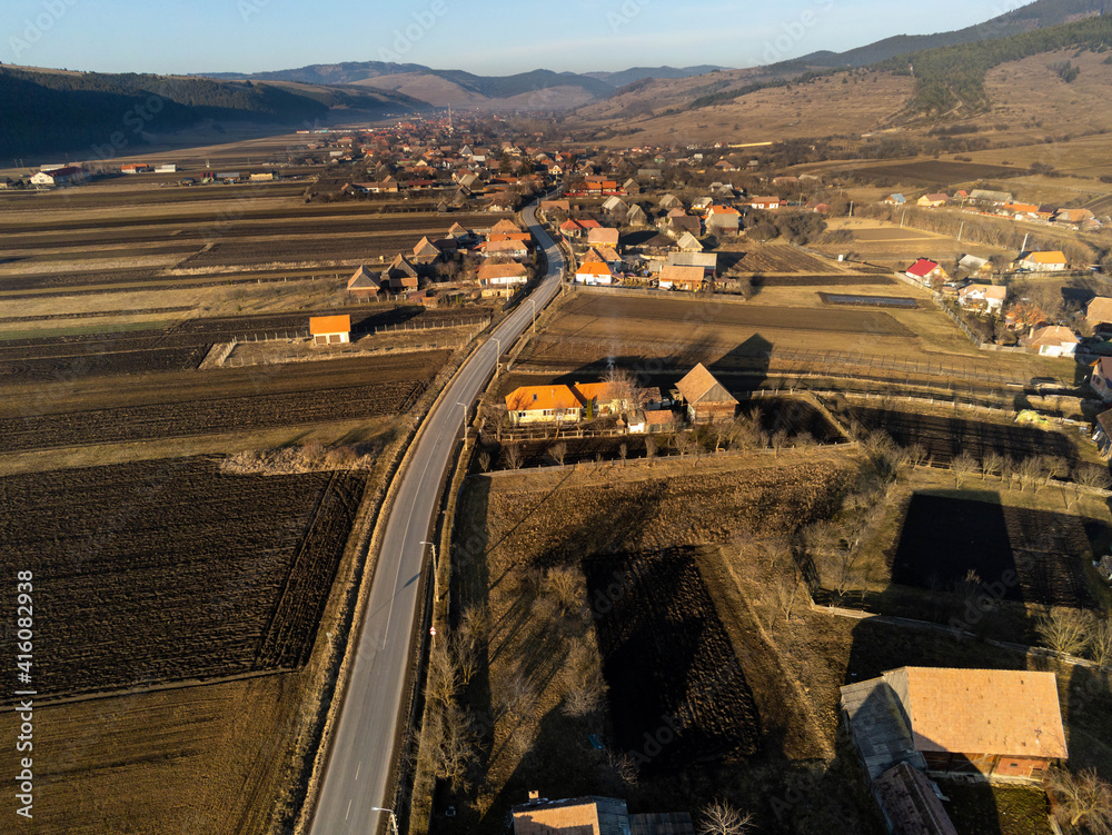 Asphalt road leading through a small hungarian village in Transylvania ...