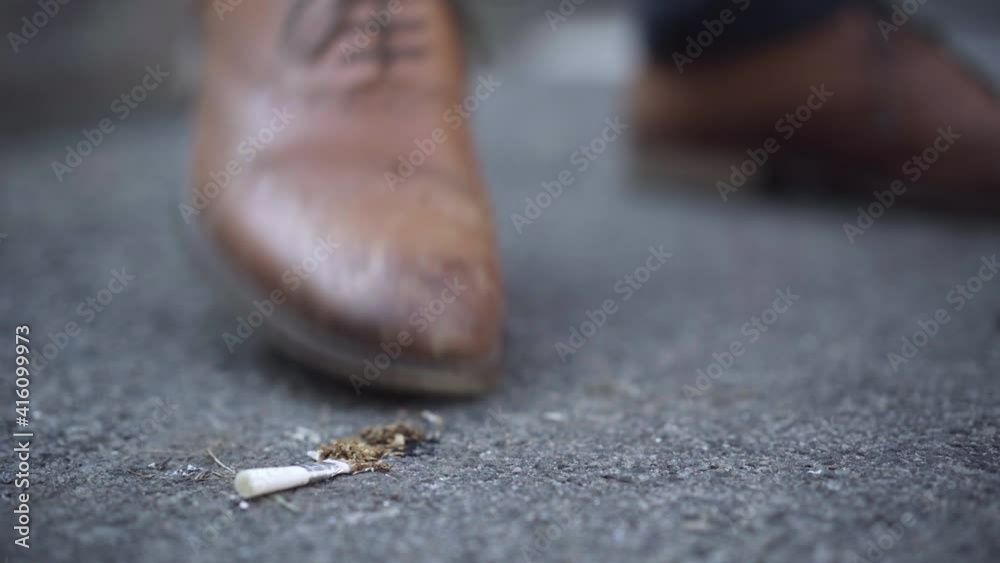 Close-up of male foot in brown stylish shoe stomping on burning ...
