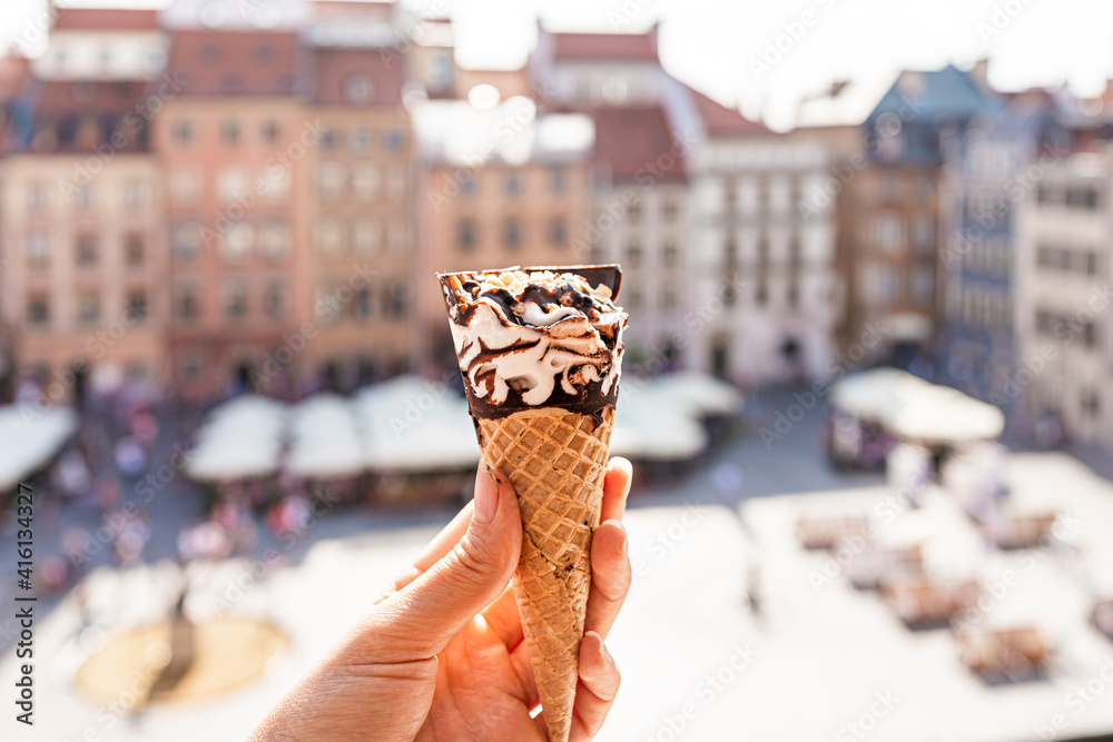 Hand holding one single white vanilla chocolate ice cream gelato cone ...