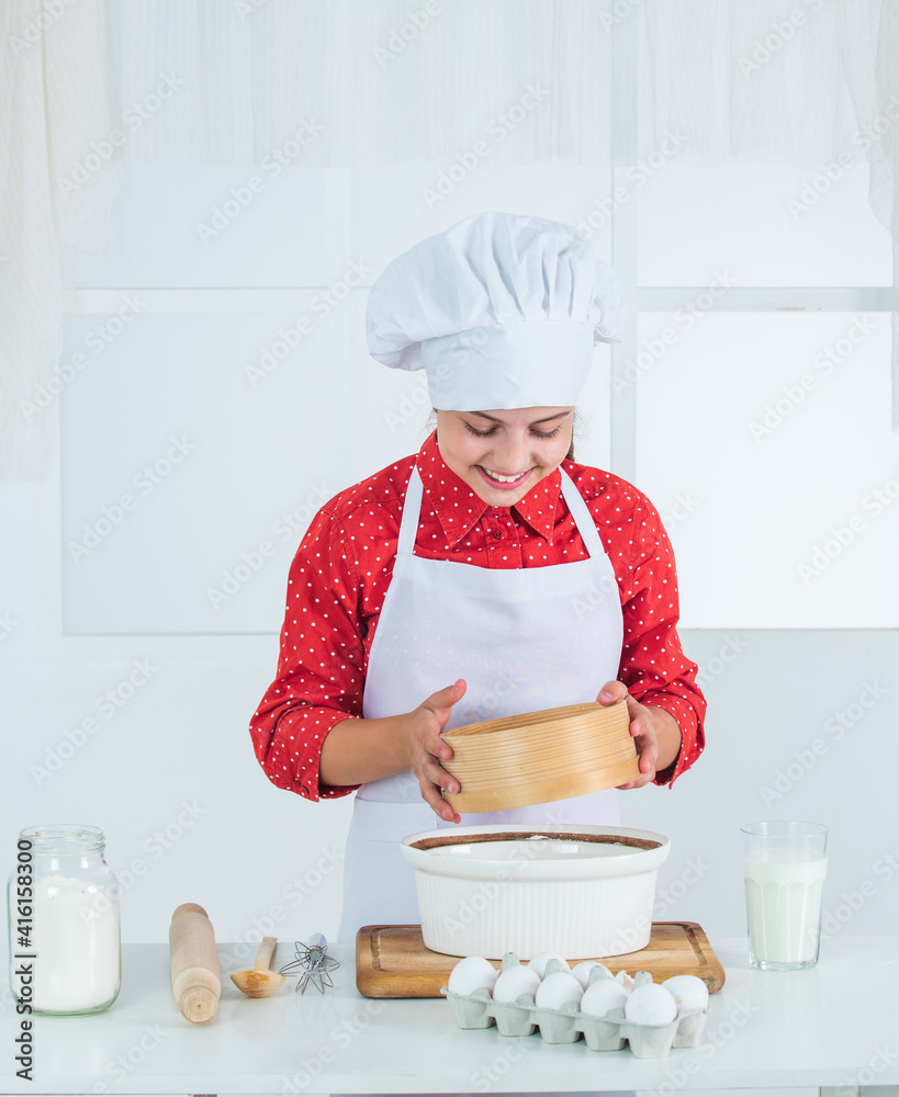 Look whats cooking. happy teen girl cooking dough. kid in chef uniform ...