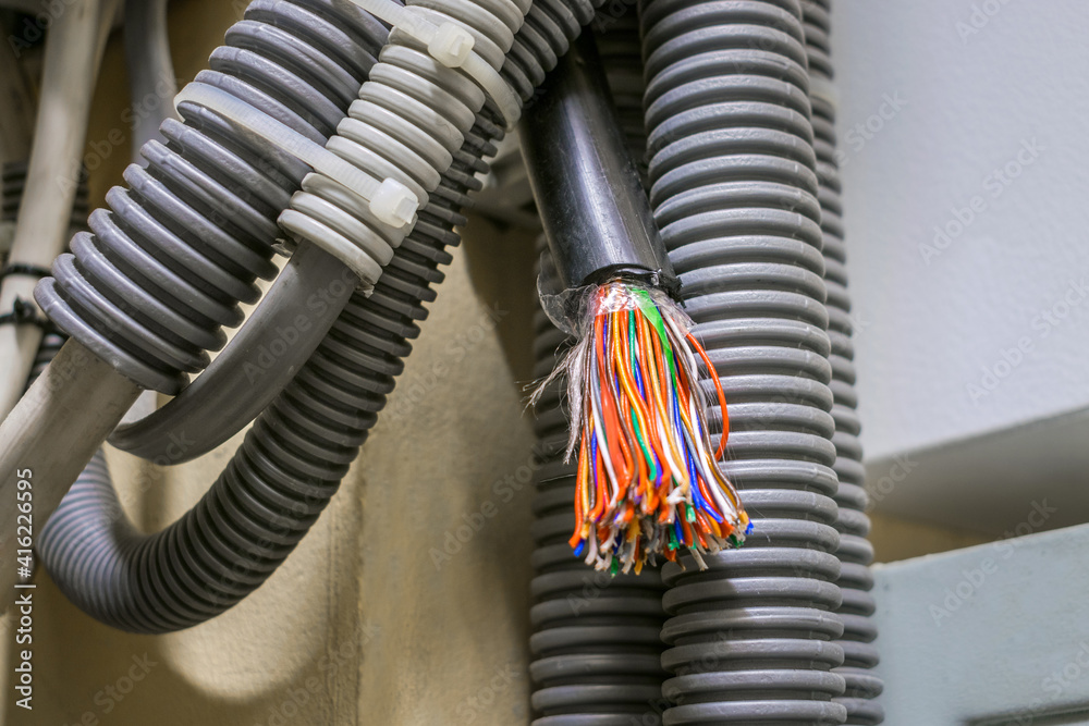 Broken cable among many other corrugated wires. Bad wiring is attached ...