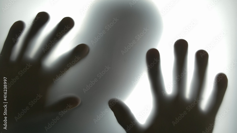 Silhouette of Man Behind Translucent Glass Touching the Surface with ...