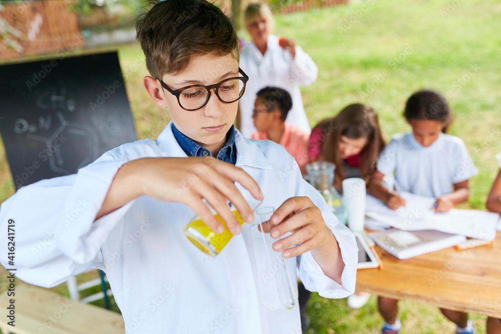 Child in a white coat doing a laboratory experiment Stock Photo | Adobe ...