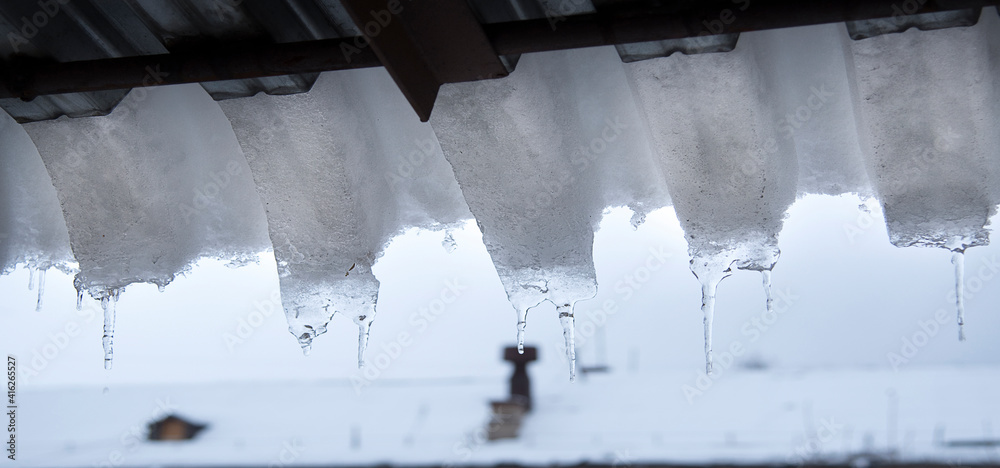 Ice and snow covers roof building, dangerous ice dams hanging from roof ...
