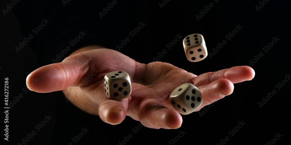 Female hand throwing dice in the air on black background. Fortune ...