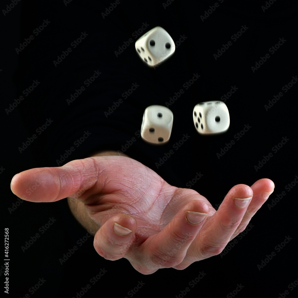 Female hand throwing dice in the air on black background. Fortune ...
