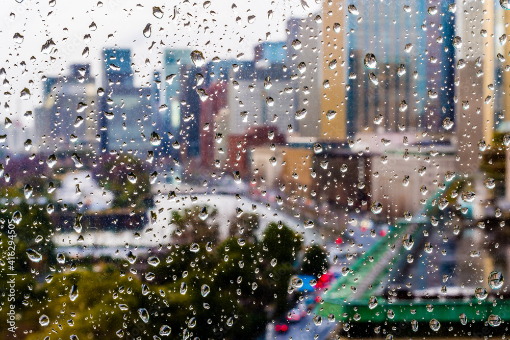 Office window covered with rain water. Water spray on window. After ...