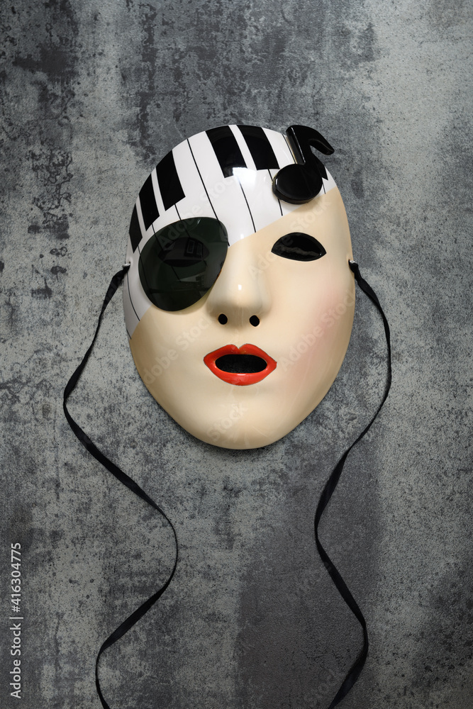 Porcelain mask of a female musical muse with keyboard and note on a ...