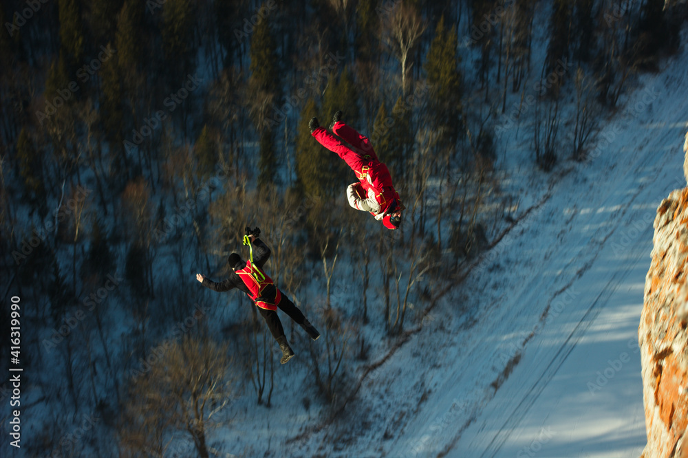 Two basejumpers athletes are in free fall after jumping from a high ...
