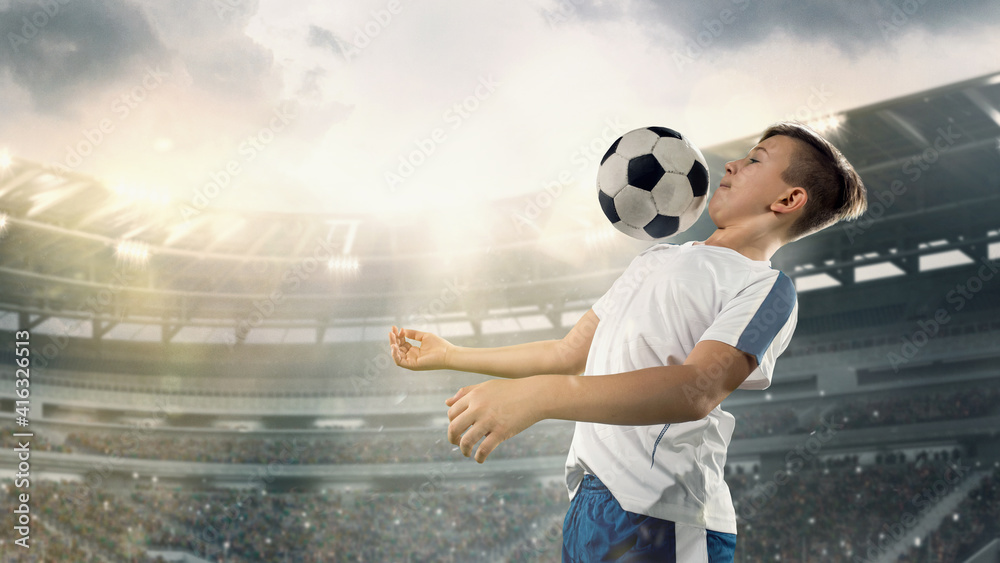 Junior football or soccer player at stadium in flashlight. Young male ...