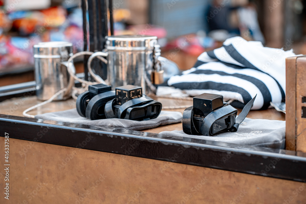 Black leather tefillin lies on the table next to black and white tallit ...