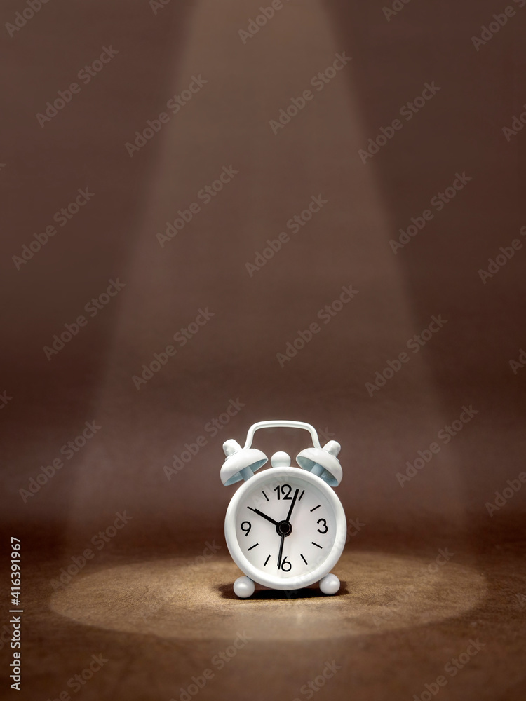 Clock in a beam of light on dark background. Business idea, financial ...