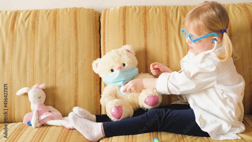 Cute preschool child girl wearing white medical uniform and eyeglasses ...