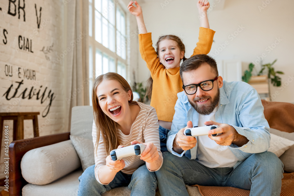 Girl supporting parents playing videogame Stock Photo | Adobe Stock
