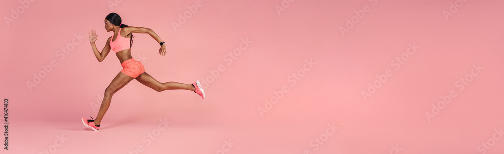 Sportswoman sprinting on a large pink background Stock Photo | Adobe Stock