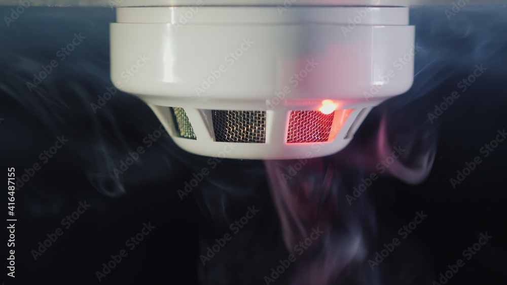 Close-up shot: The smoke detector is triggered by a trickle of dum, the ...