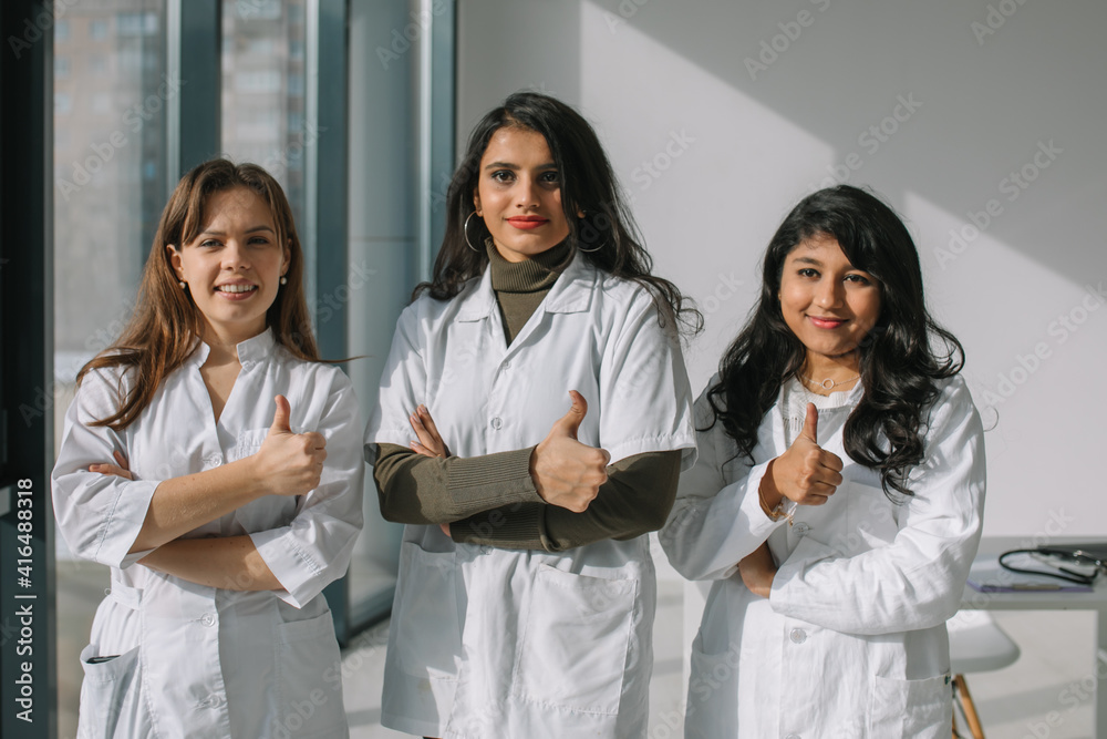 Foto de Three young women doctor of different nationalities look into ...