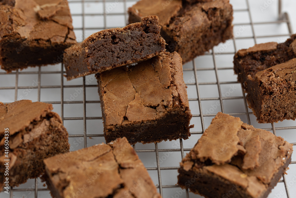 Pieces of freshly baked brownies in a square form on a cooling tray ...
