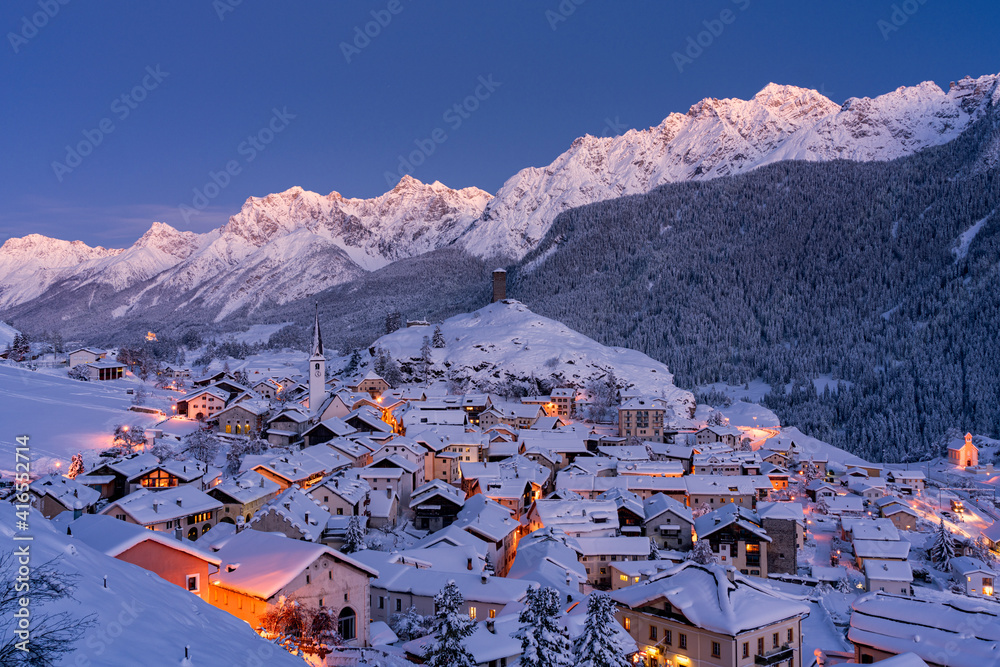 Traditional houses covered with snow during the winter dusk, Ardez ...