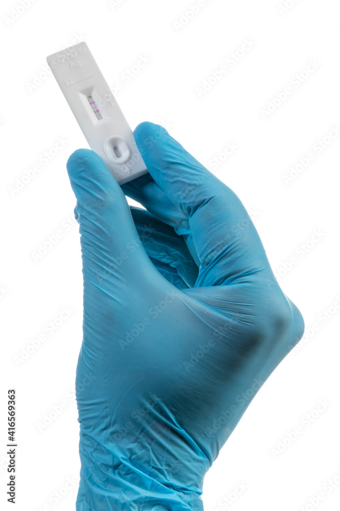 Hand in disposable glove holding positive sars-cov-2 rapid antigen test ...