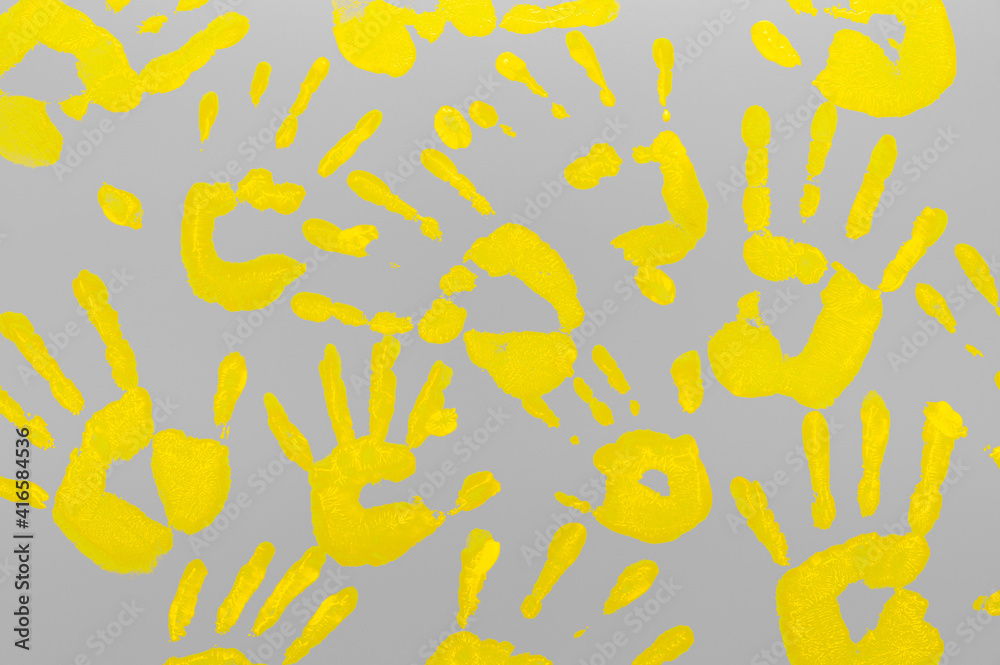Bright yellow family handprints on a gray background. Positive and hope ...