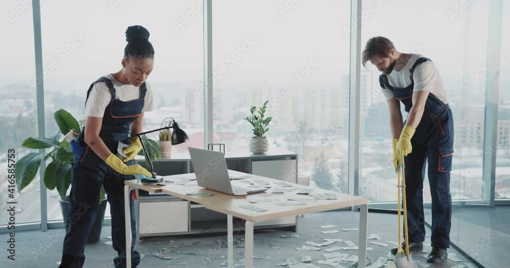Cooperative Couple Of Multi Ethnic Man And Woman Janitors In Blue Uniform Cleaning Corporate