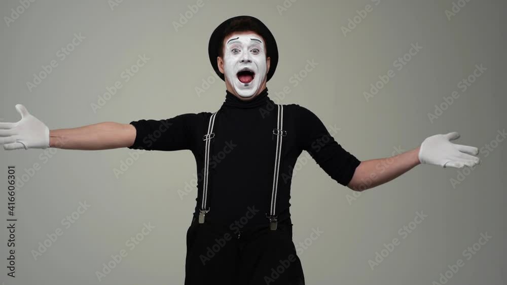 Middle shot portrait of cheerful male mime opening arms in welcoming ...