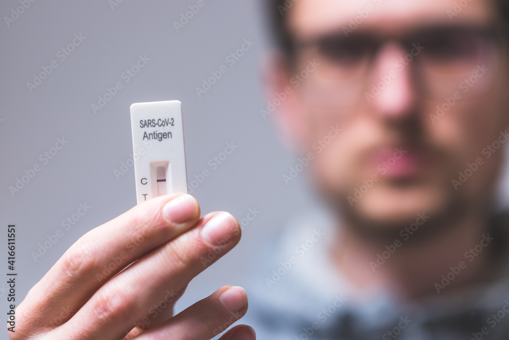 Express corona test at home: Close up of young man holding a negative ...