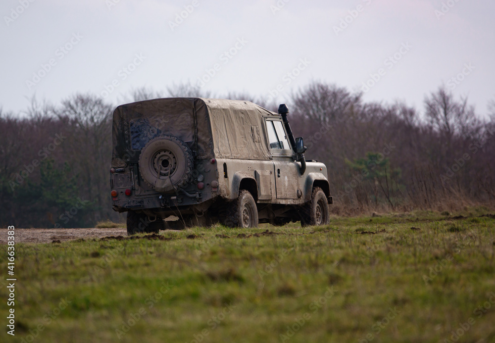 british army land rover defender 4x4 speeds along a dusty dirt track ...