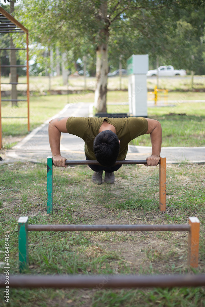 Hombre joven haciendo ejercicios de barra baja en ñu guazu luque ...